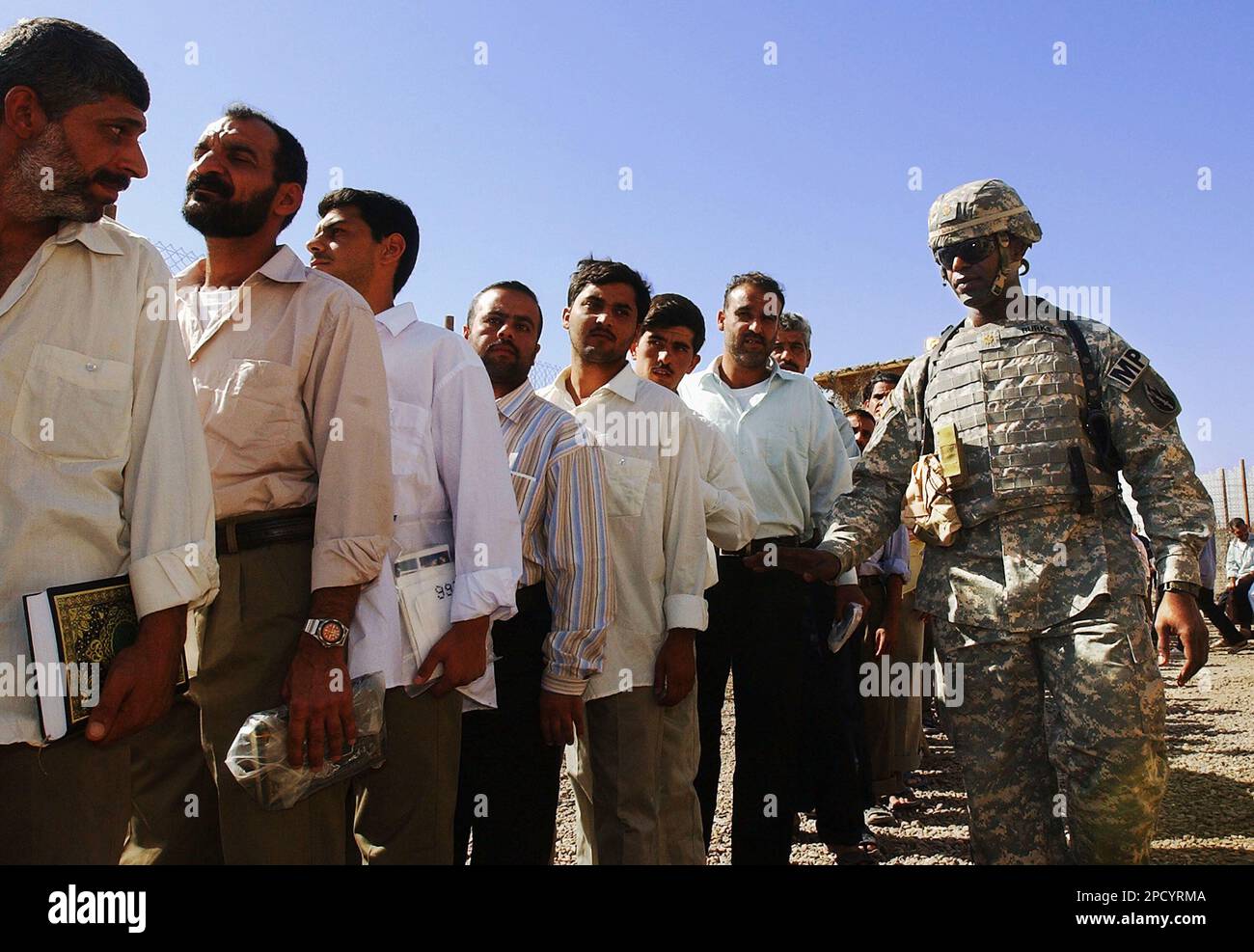 A U.S. military police officer guards detainees waiting to be released ...