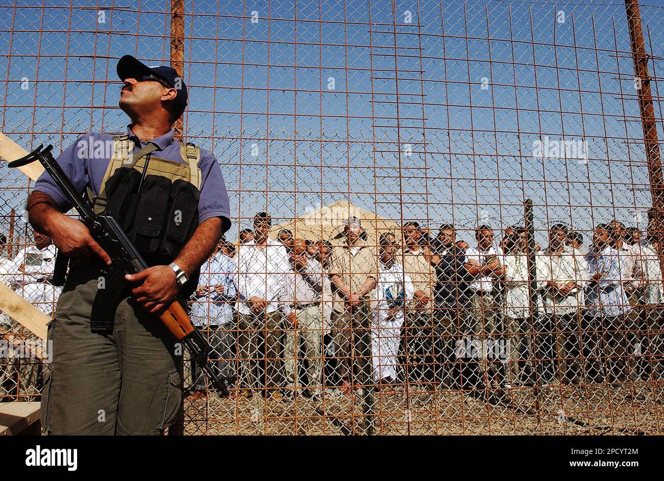Iraqi prisoners wait to be released as a security guard for the Iraqi ...