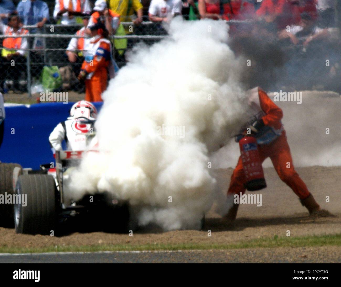 British F1 driver Jenson Button, left, alights from his burning Honda ...