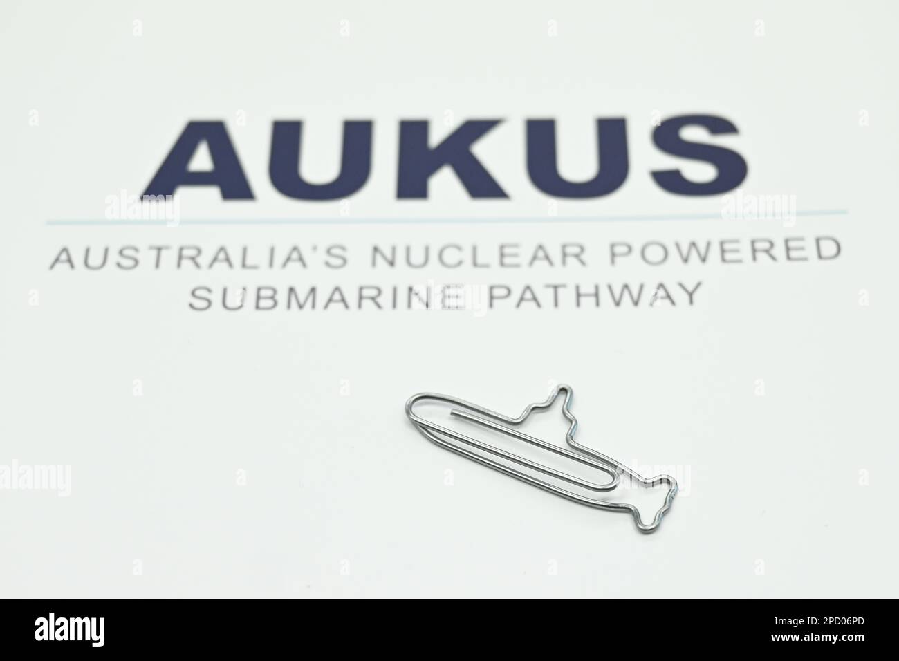 A submarine shaped paperclip is seen next to an AUKUS logo on a press ...