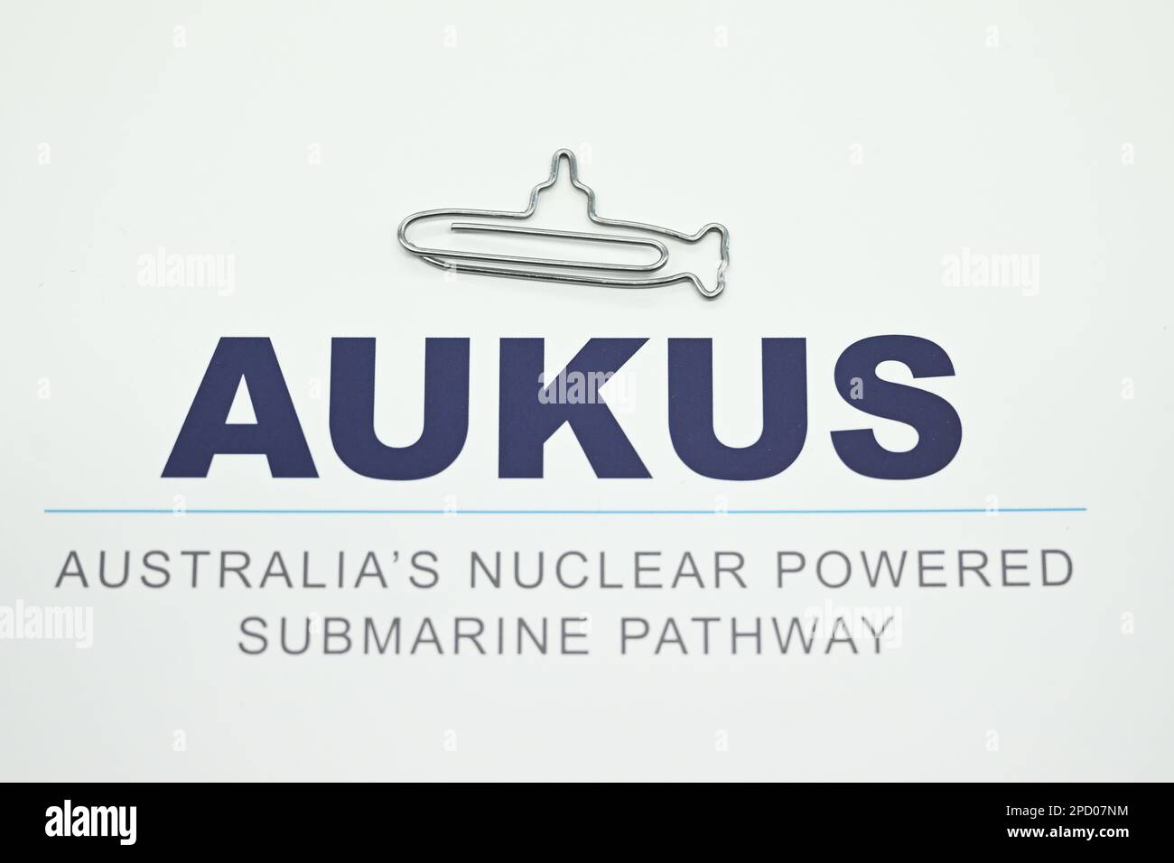A submarine shaped paperclip is seen next to an AUKUS logo on a press ...