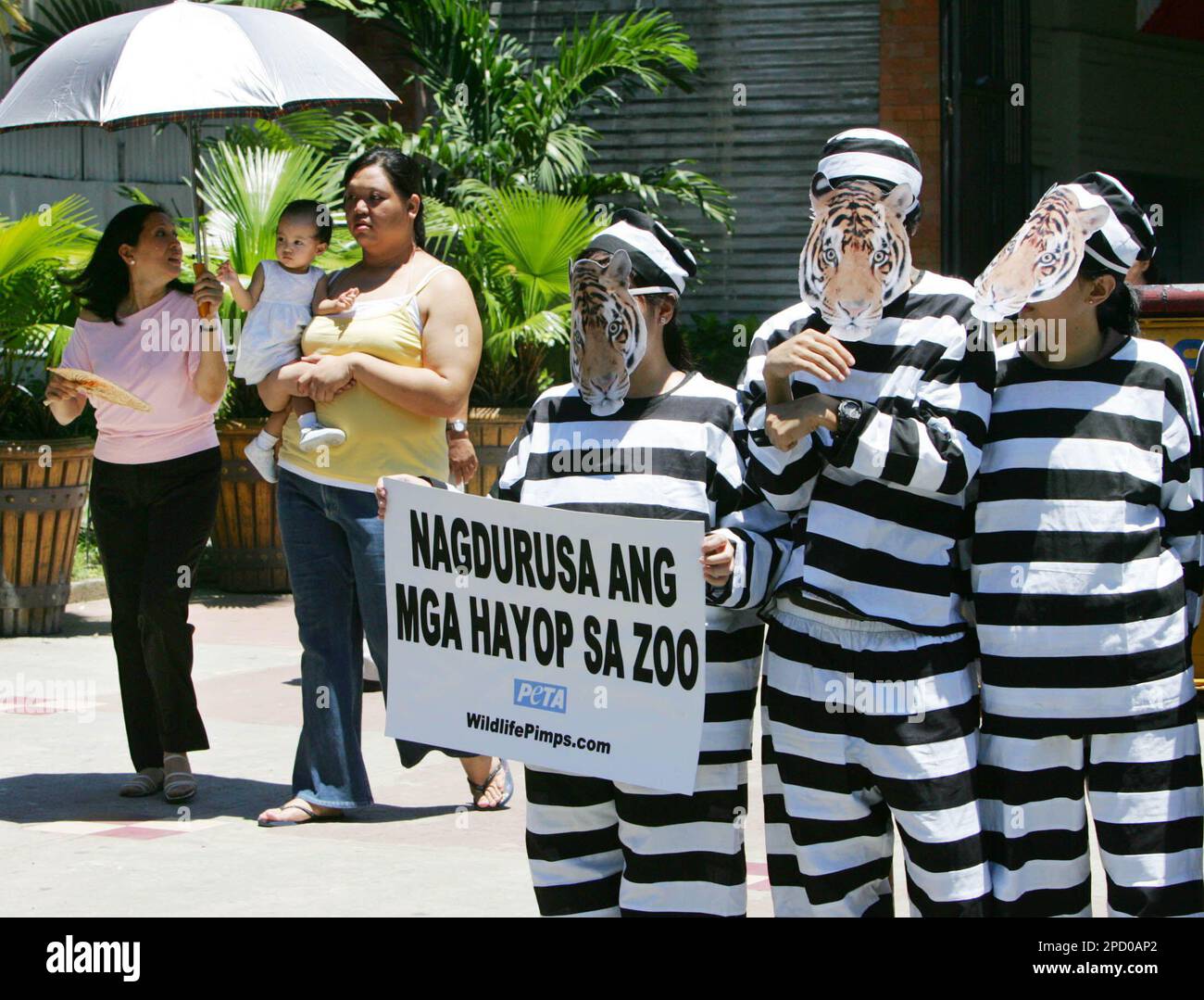 Zoo visitors pass by a group of members of PETA or People for the ...