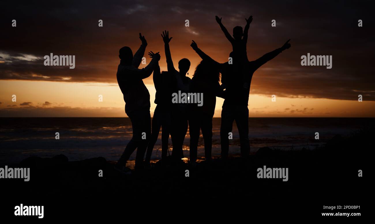 Freedom, sunset and silhouette of people at the beach while on a summer ...