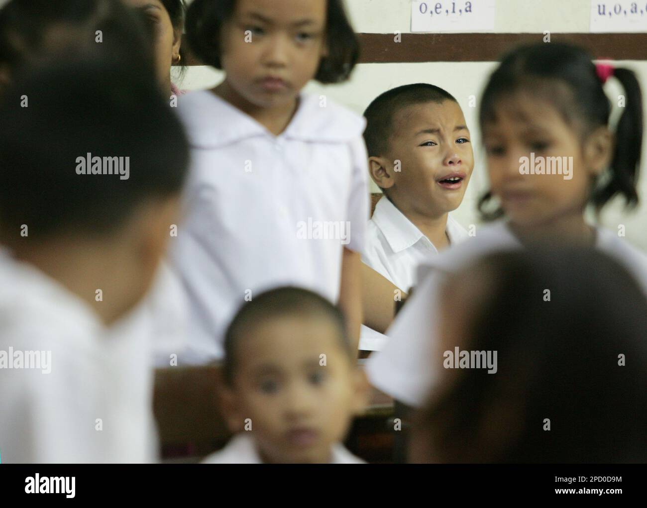 A Filipino boy cries as he left by his mother inside the classroom ...
