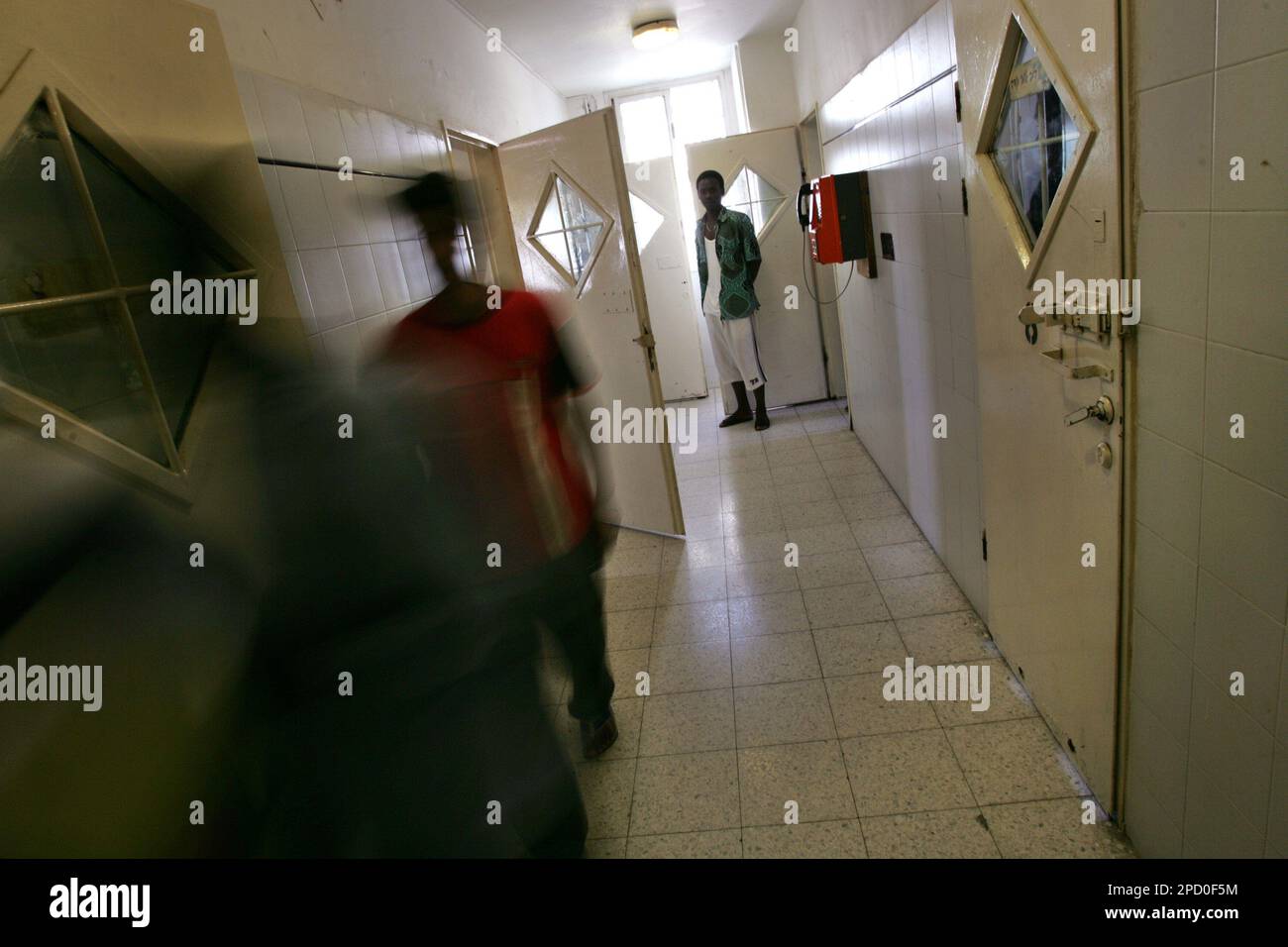 Refugees from the Sudan walk inside a cell-block at Maasiyahu Prison ...