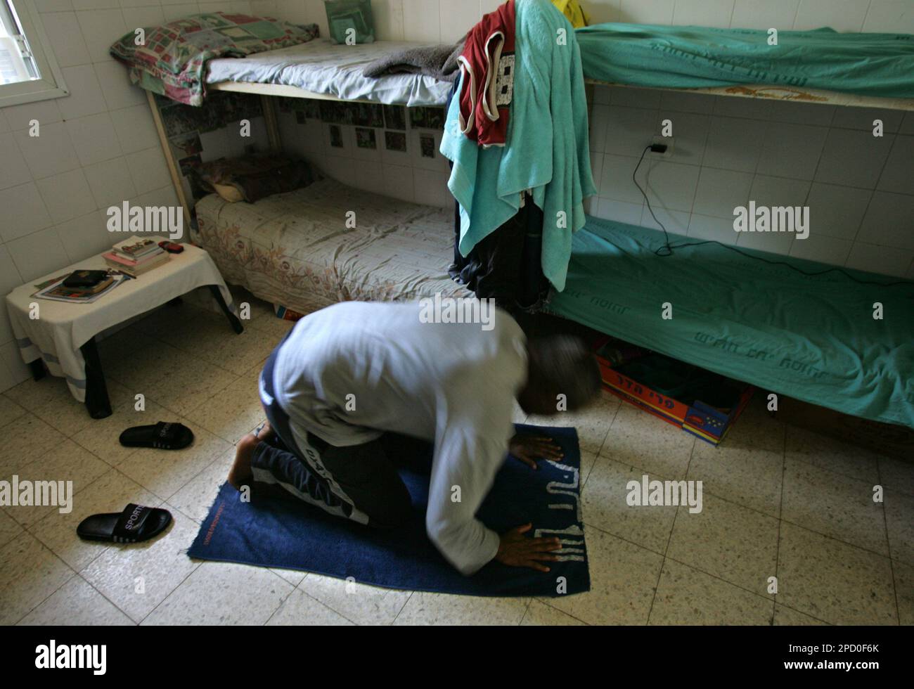 A muslim refugee from the Sudan prays in a cell at Maasiyahu Prison, in ...