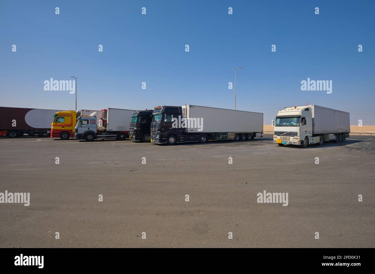 Big rig, semi trucks are lined up and parked at one of the rest stops ...