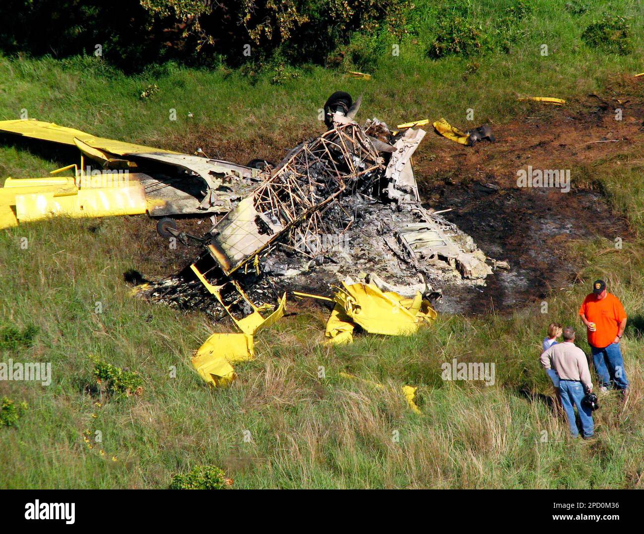 Investigators look over the wreckage of a small airplane which crashed ...