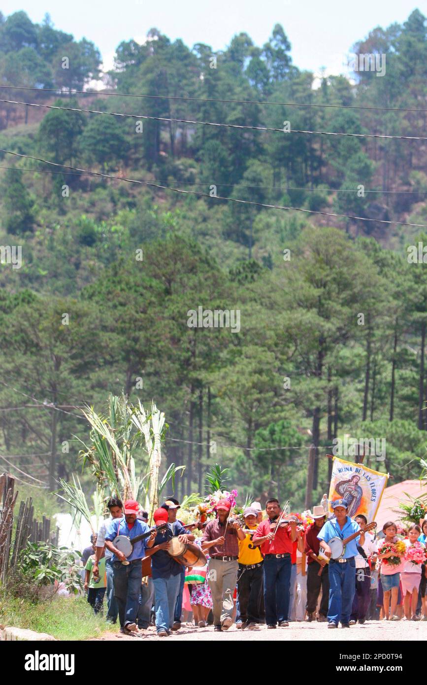 Villagers walk in a procession during the Festival of Flowers to honor ...