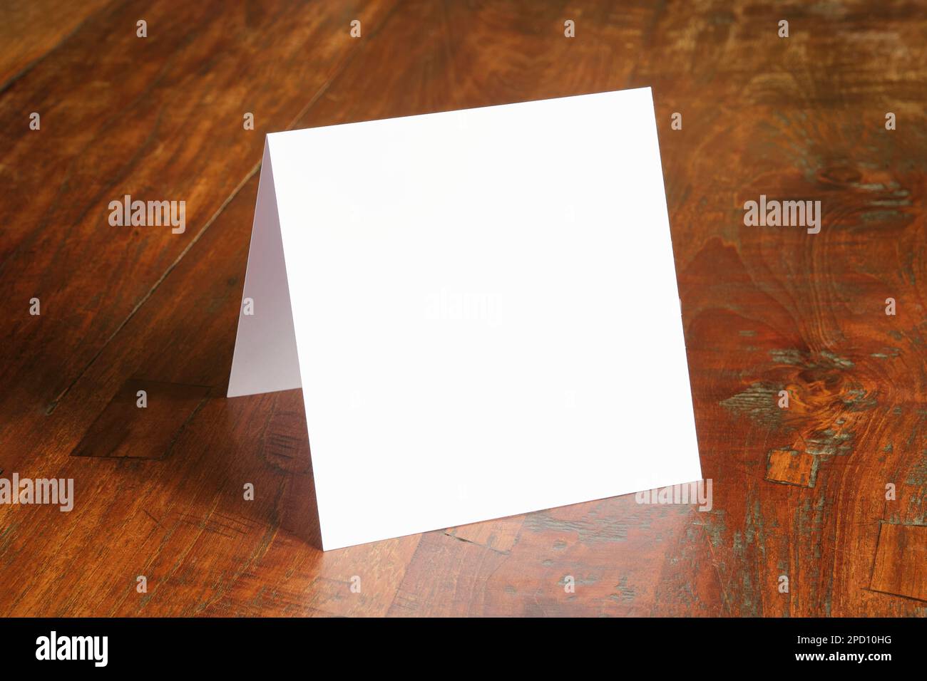 Standing blank empty square greeting card mock up on dark wooden ...