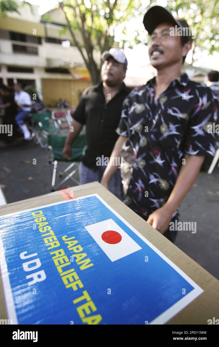 Indonesian relief workers unpack cardboard boxes of relief and medical ...