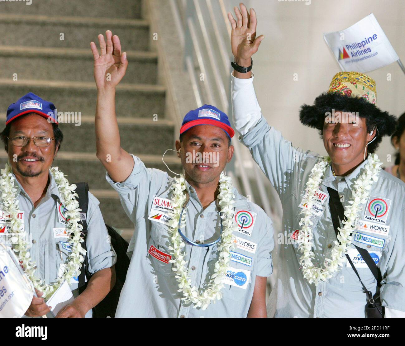 Filipino mountaineers Leo Oracion, right, and Erwin Emata, center, wave ...