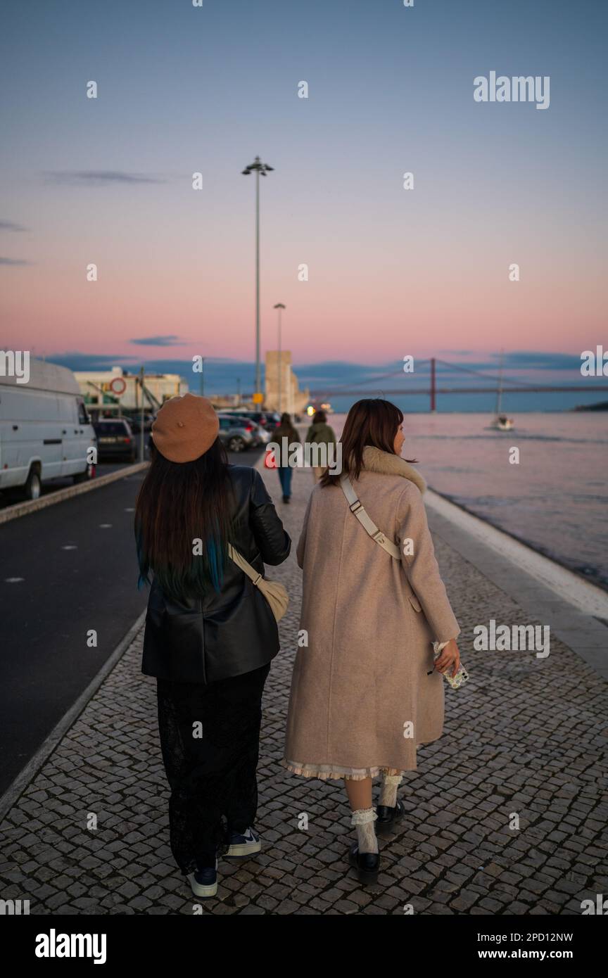 People enjoying the sunset in Belem promenade by Tagus River, Lisbon ...