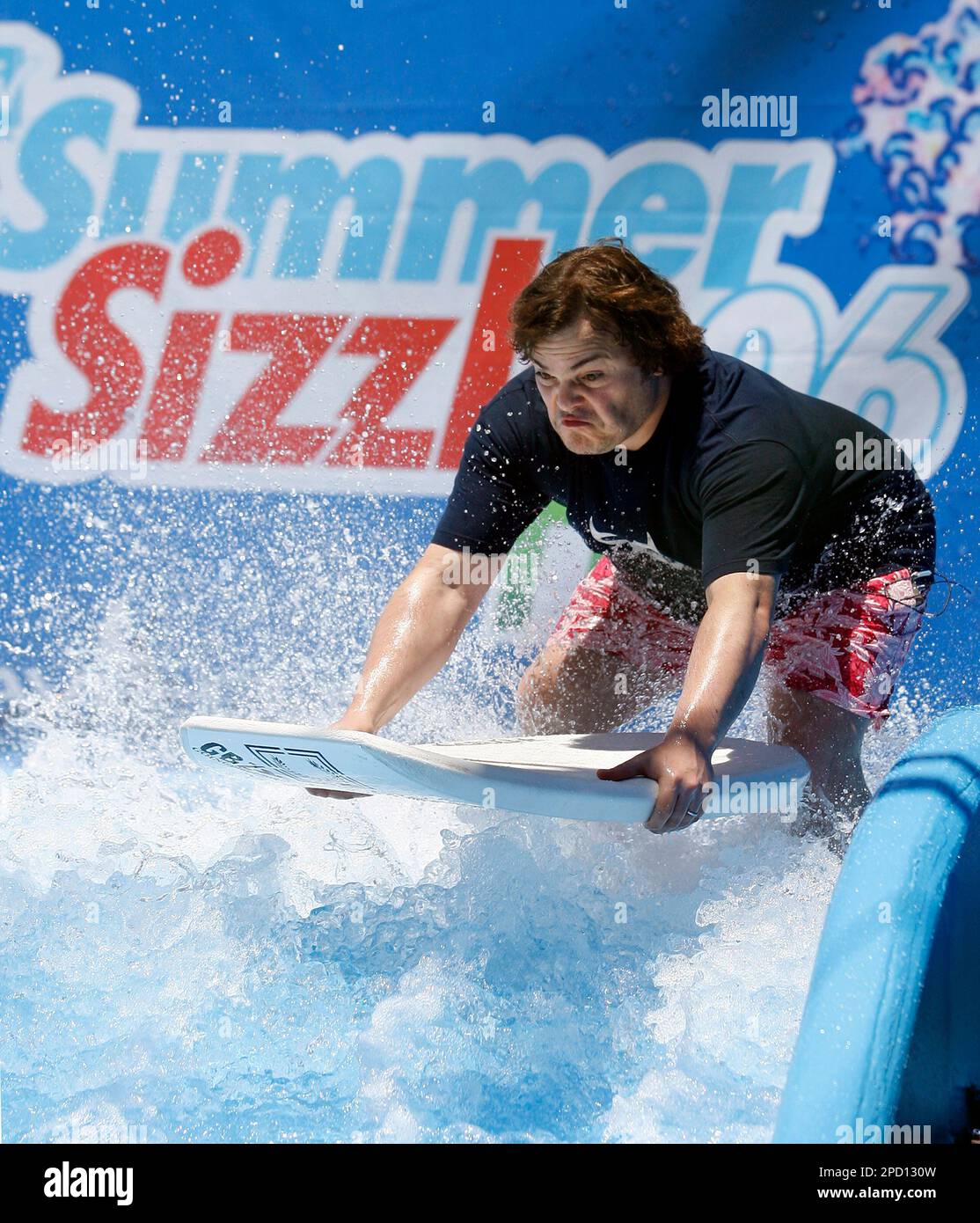 Actor Jack Black makes a face as he jumps into the Wave House wave pool ...