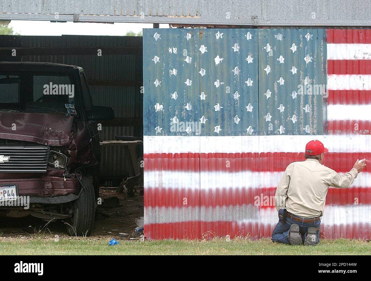 Roger Fuller applies a coat of red paint Sunday, May 28, 2006, as he ...