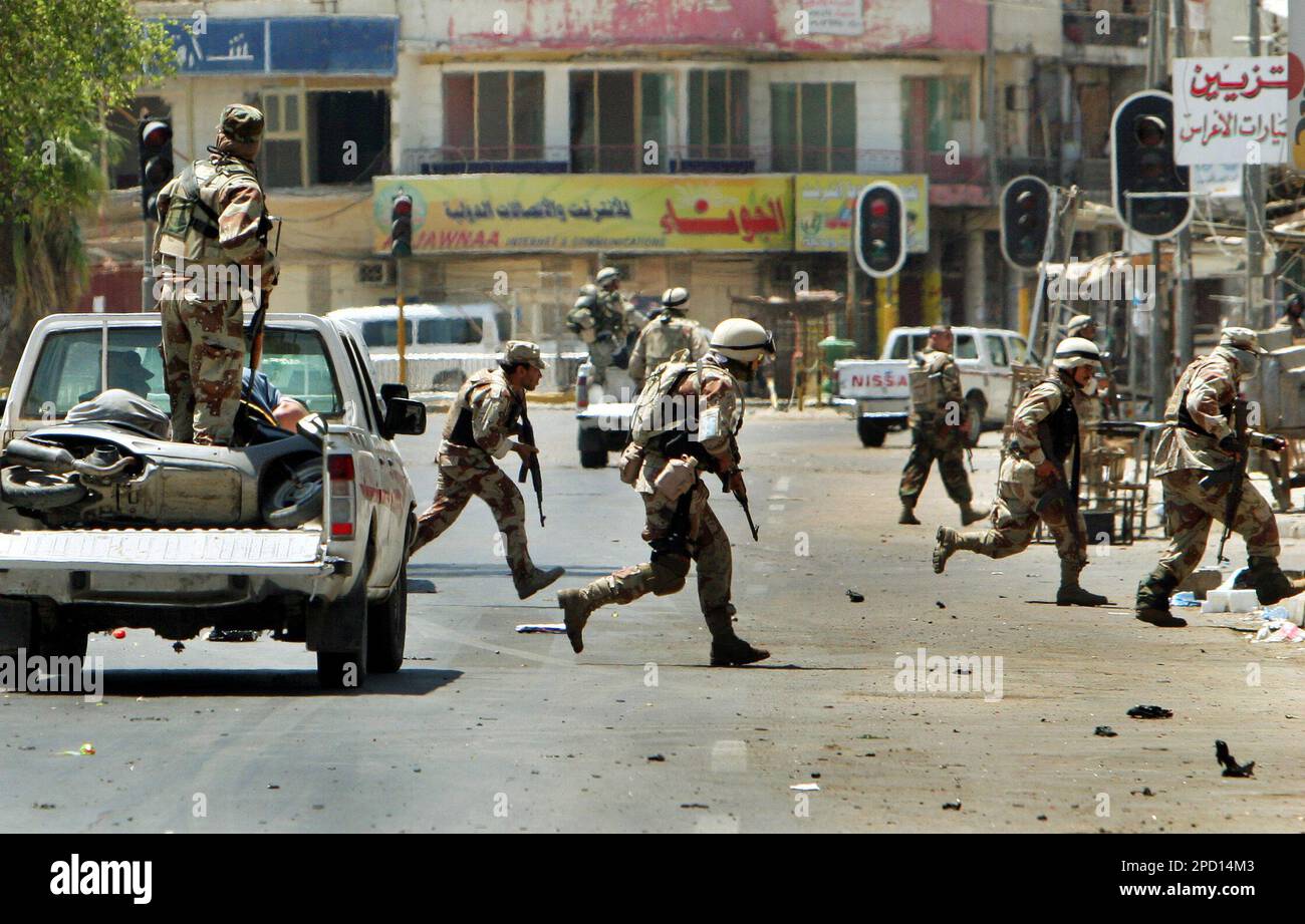 Iraqi soldiers engage in clashes, as two suspects are held in the back ...