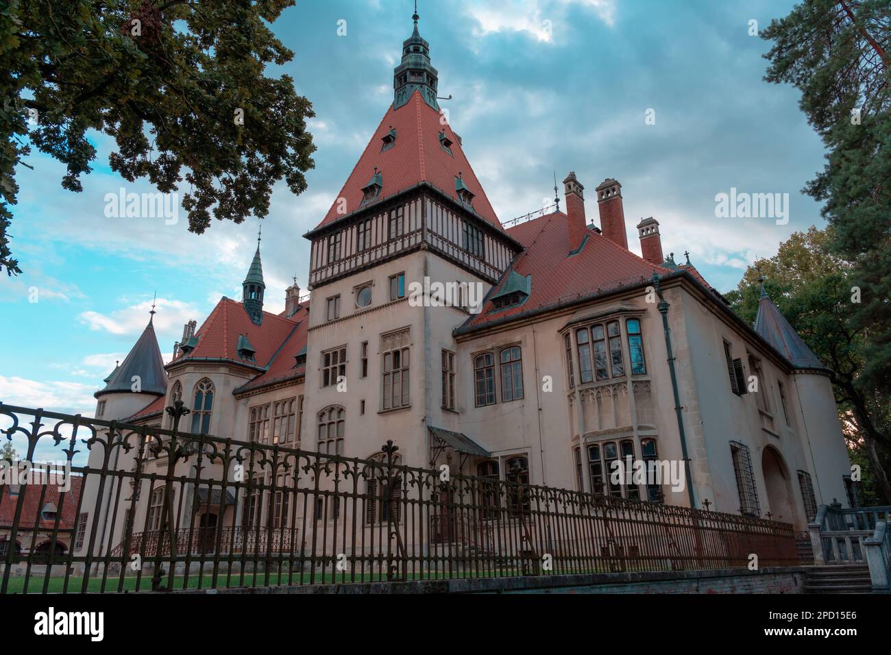 A black wrought iron fence encircles a large, stately building with an ...