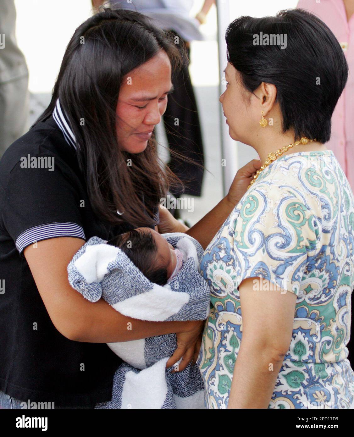 Philippine President Gloria Macapagal Arroyo, right, consoles an ...