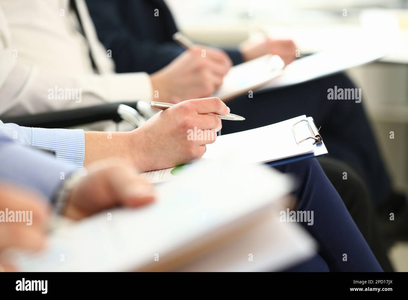 Businessmen are holding documents while taking notes at seminar Stock ...