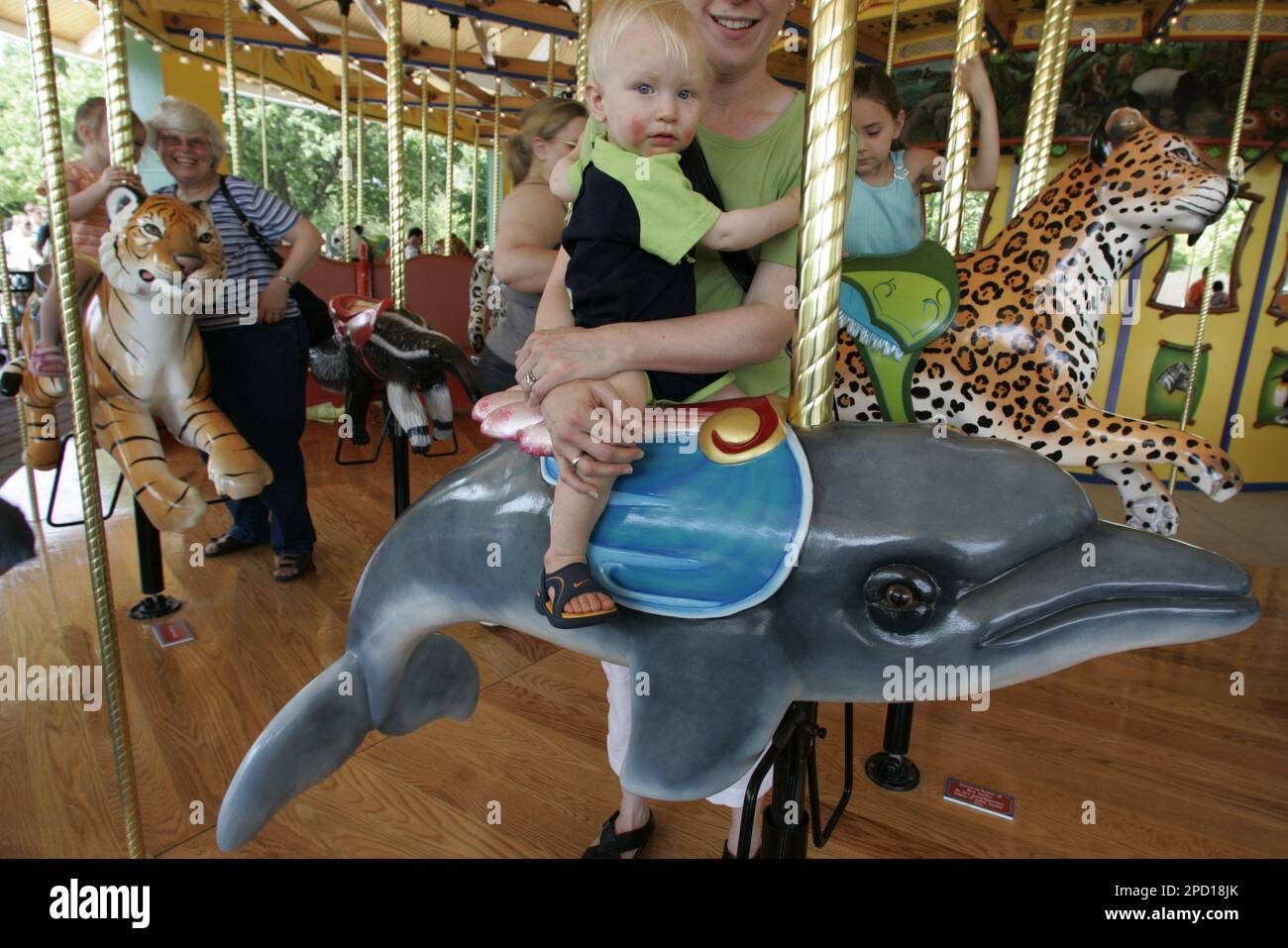 Tyler Jackson rides the Brookfield Zoo's new carousel with the help of ...