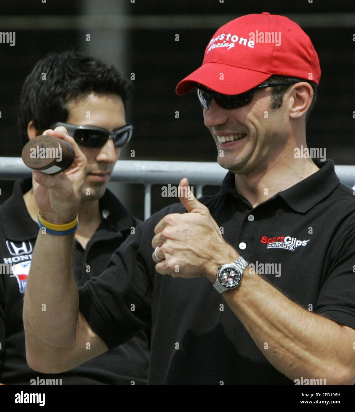 Max Papis, of Italy, gestures as he holds a ring awarded to ...