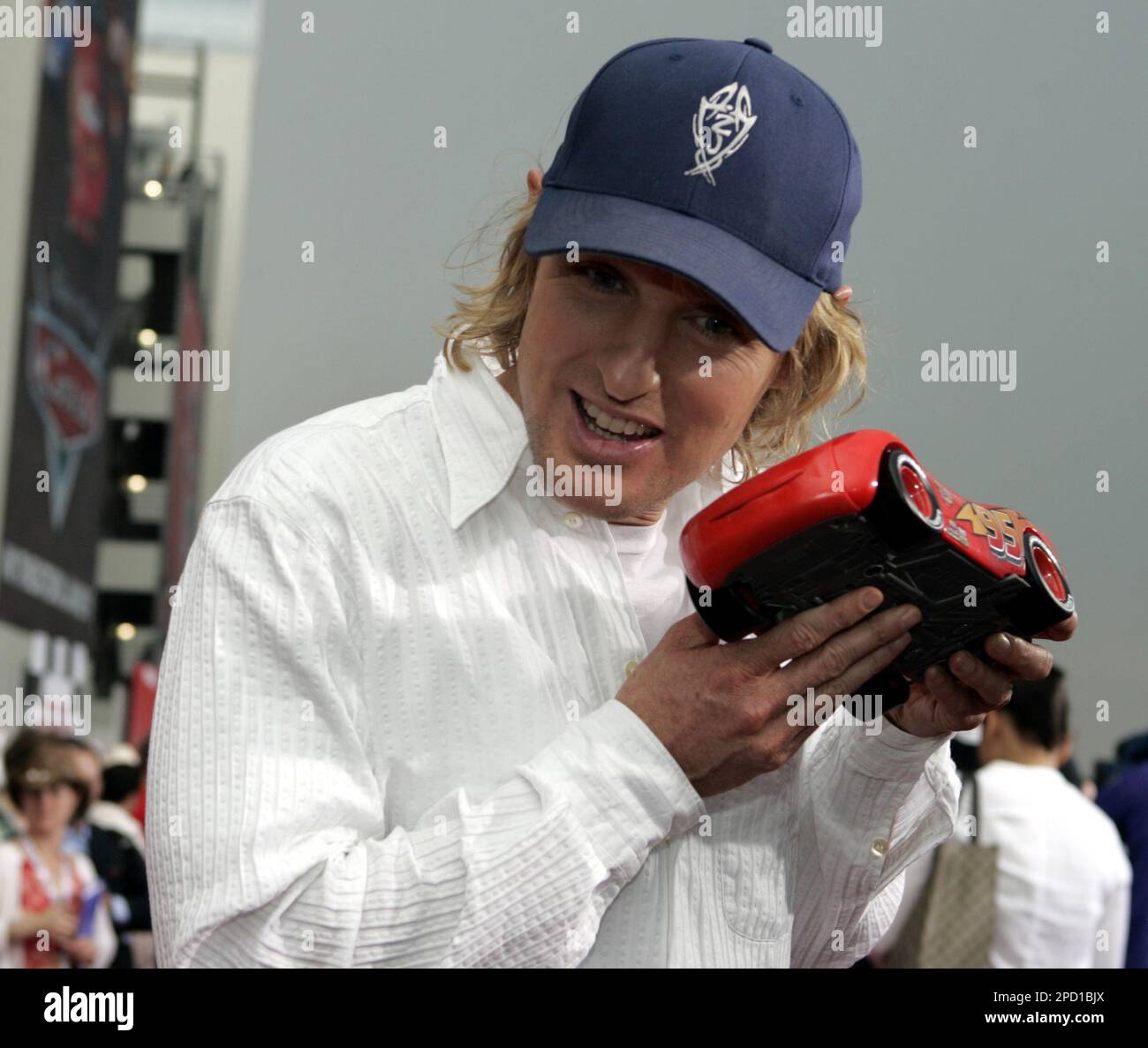 Owen Wilson listens to a model car from the movie "Cars" as he arrives ...