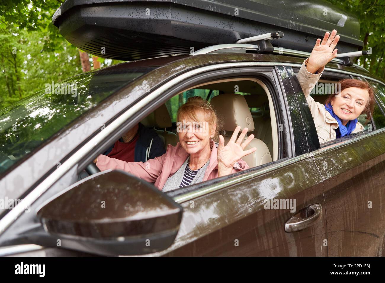 Cheerful senior women waving hands through windows while traveling in ...