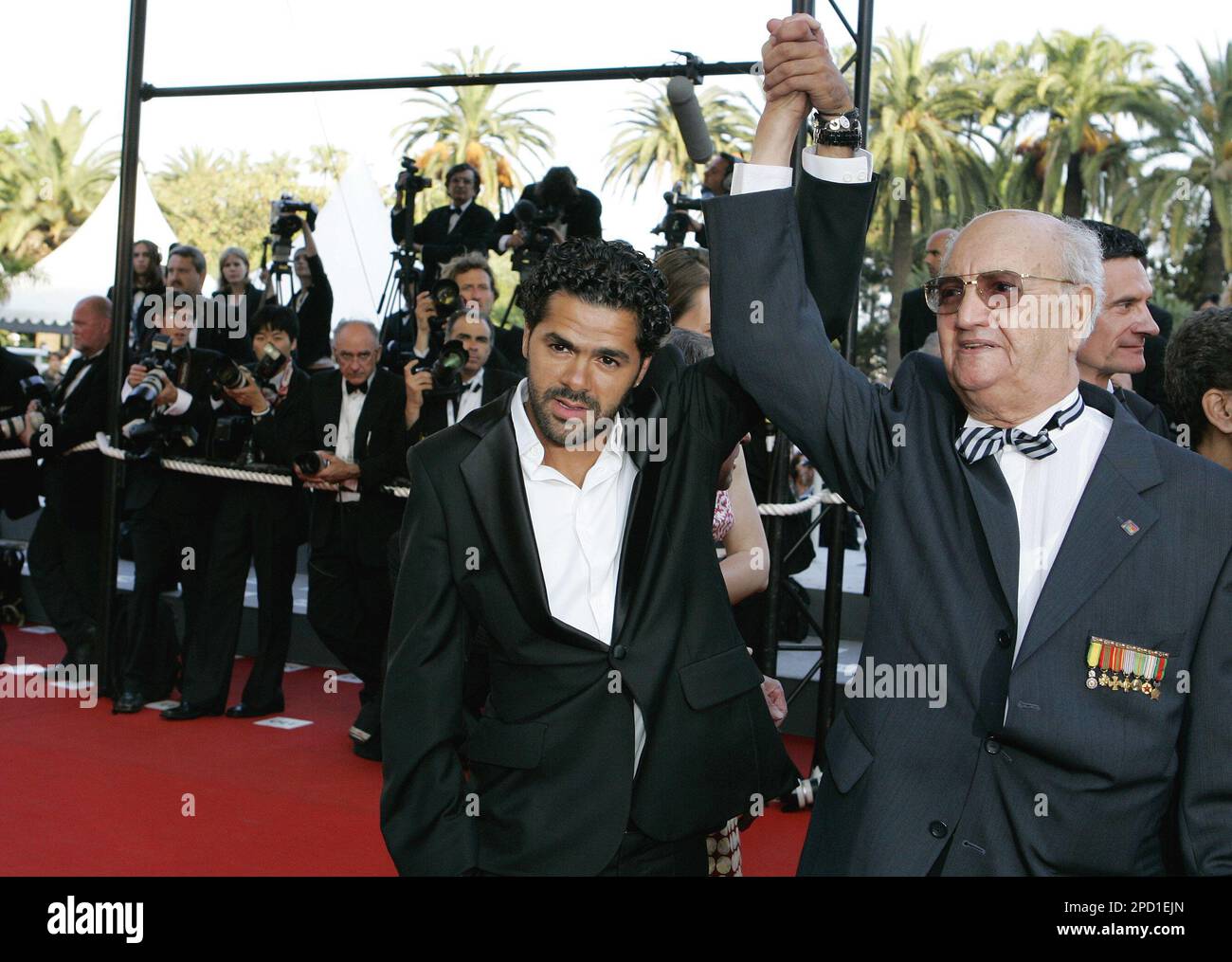 French actor Jamel Debbouze raises hands with a World War II veteran as ...