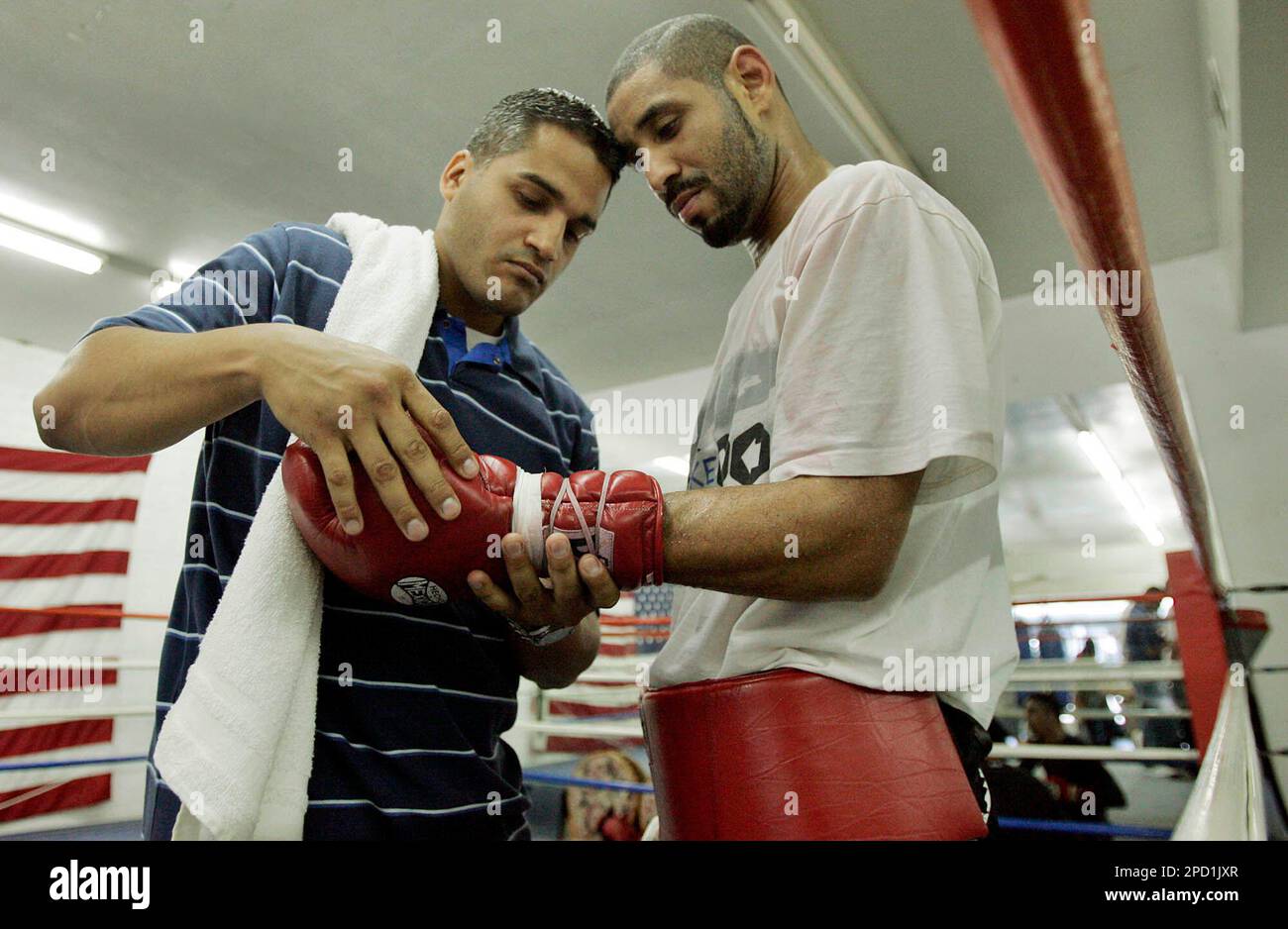 Ricky Funez, left, removes the gloves from WBC Lightweight Champion ...