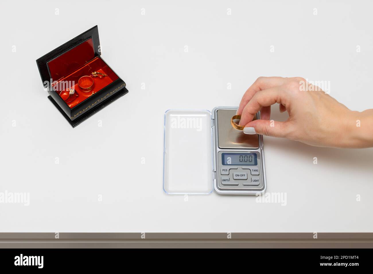 a person puts an item of jewelry on a small scale. scales for small ...