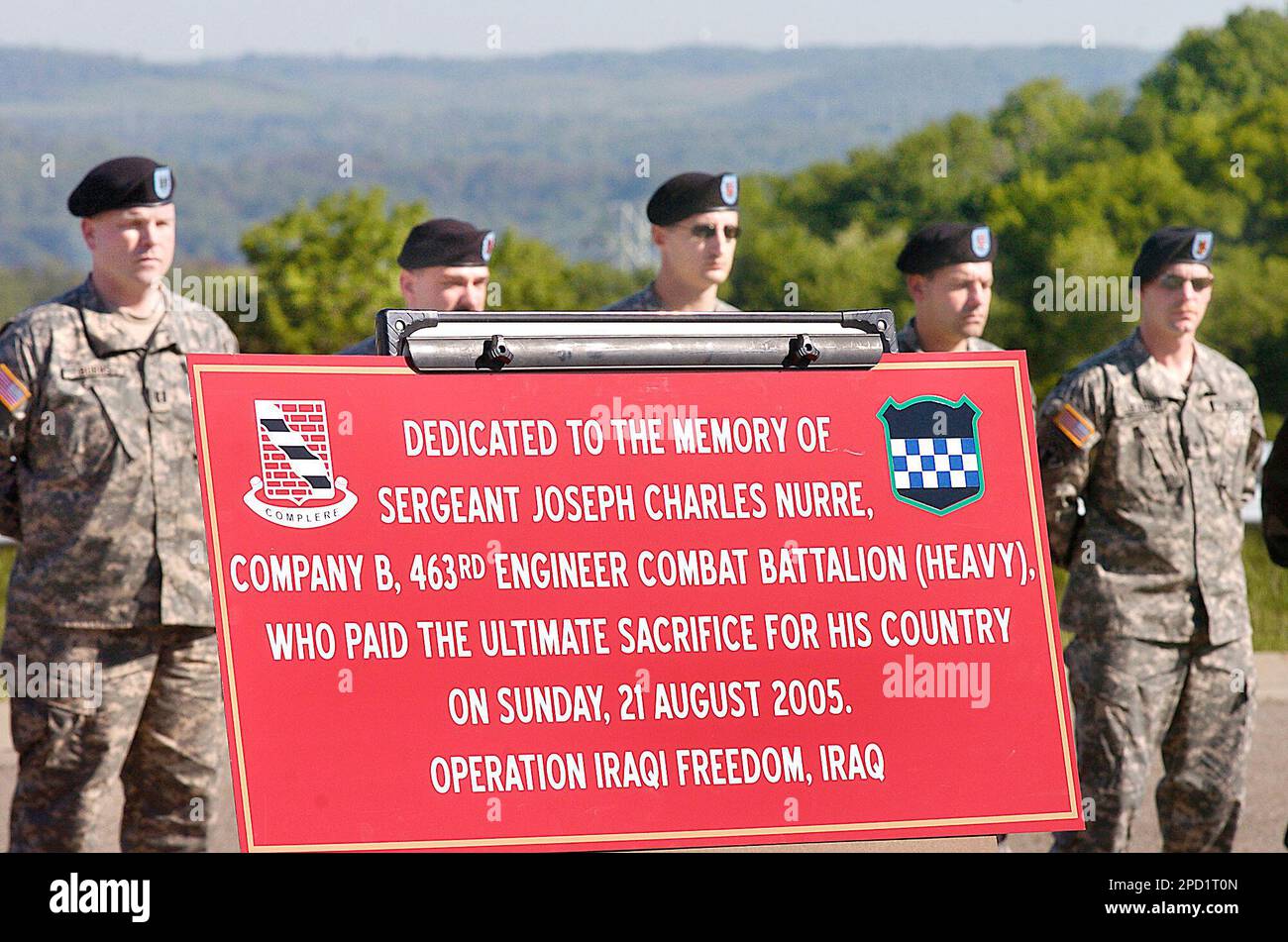 Members of the 463rd Engineer Combat Battalion stand behind a sign ...