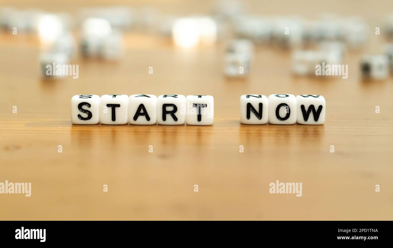 Start now slogan in white block letter beads Stock Photo - Alamy