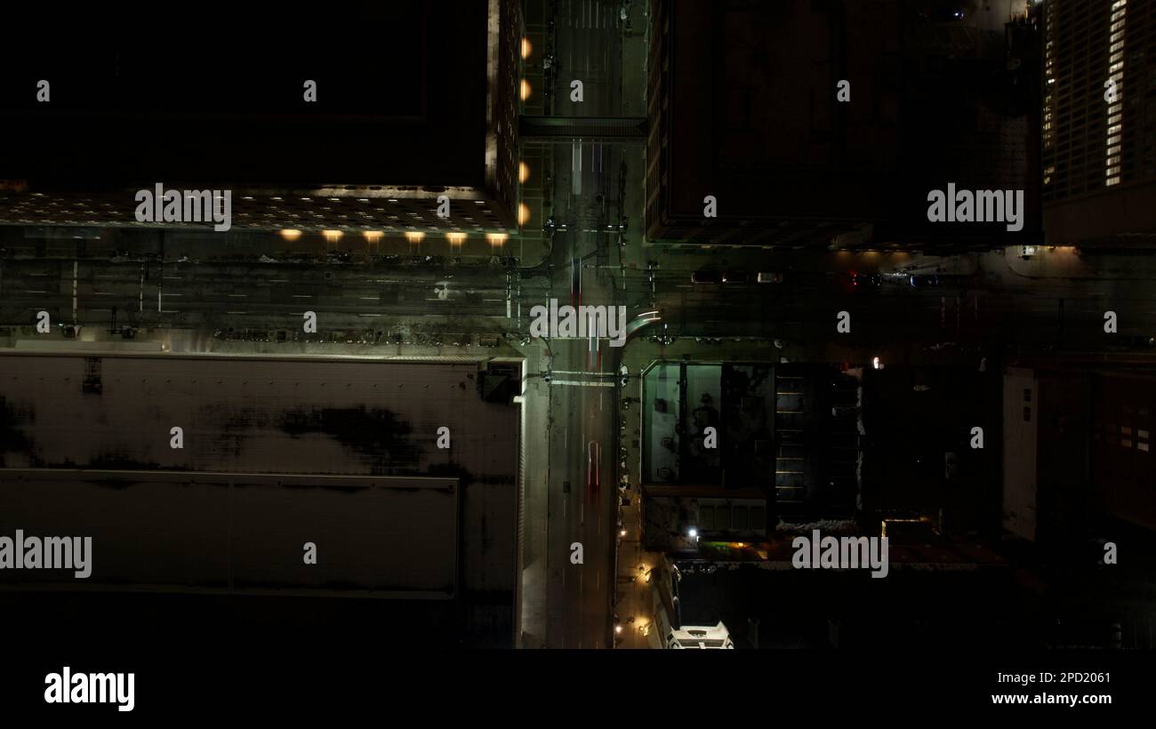 An aerial view of a nighttime downtown city street lit up with ...