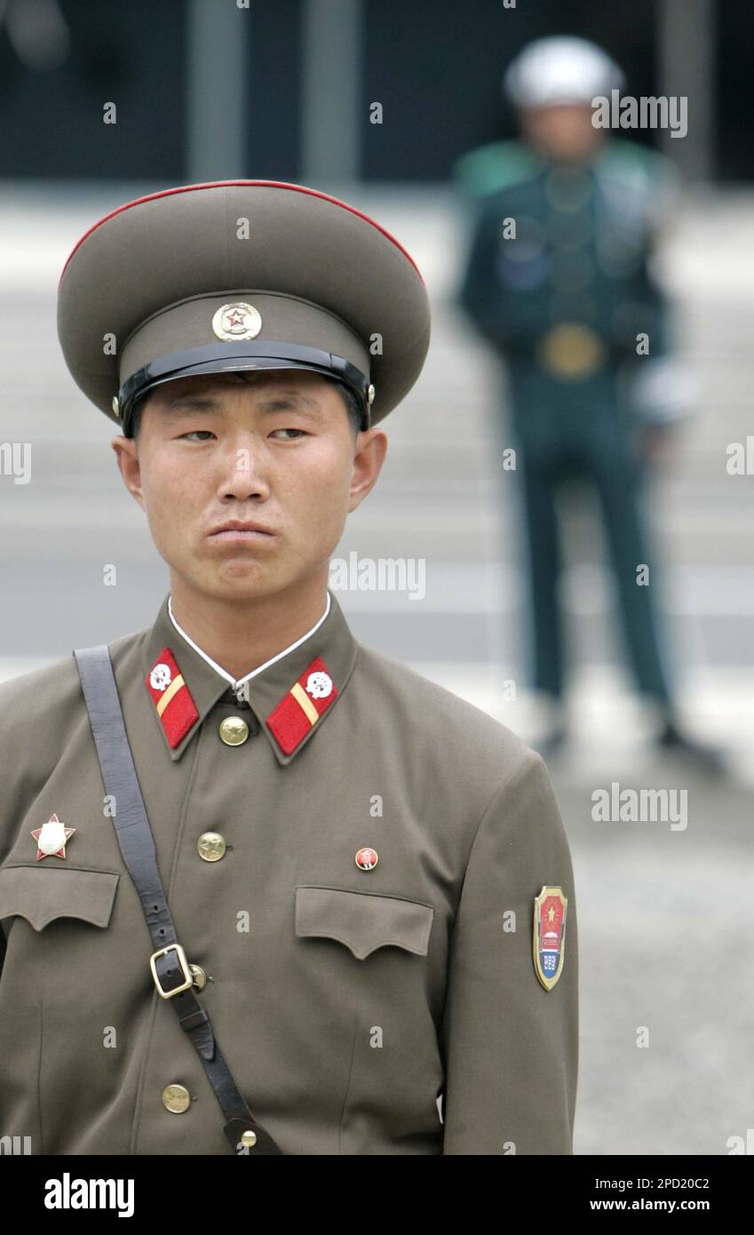 A North Korean soldier stands guard in front of a South Korean soldier ...