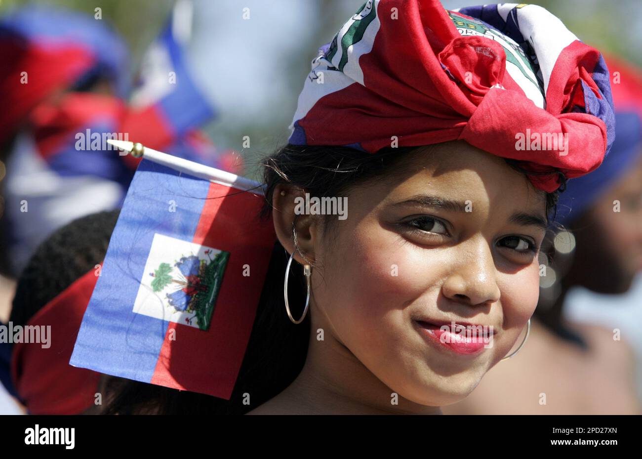 Perla Oquendo, 10, wears a Haitian flag in her hair as she marches in a ...