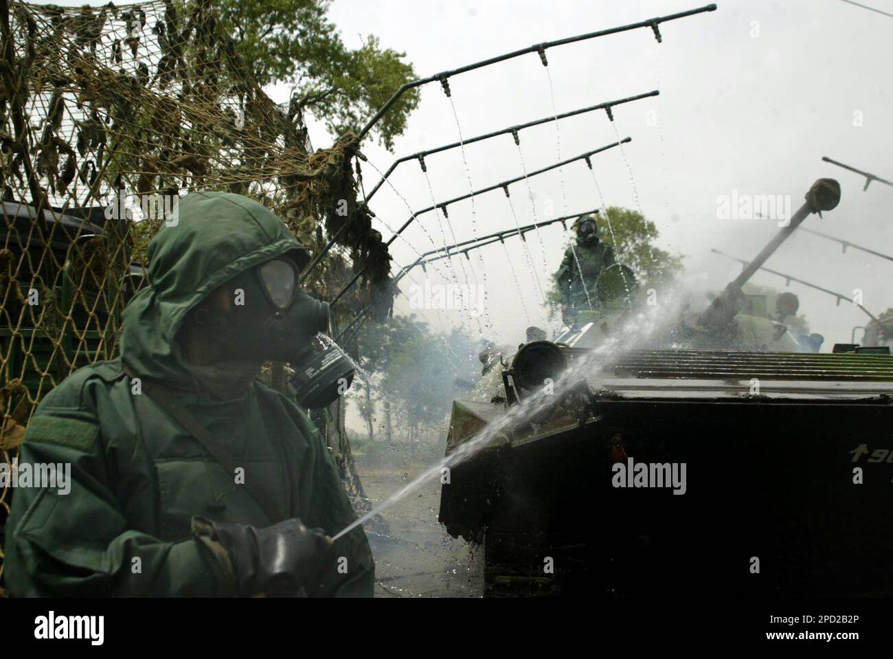 An Indian Army soldier wears protective suit and washes a tank, during ...