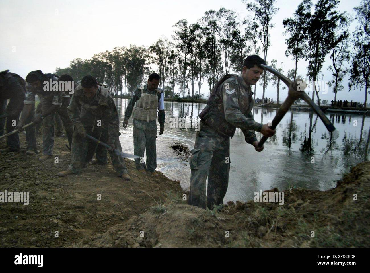 Indian Army soldiers dig earth to make space for a pontoon bridge as ...