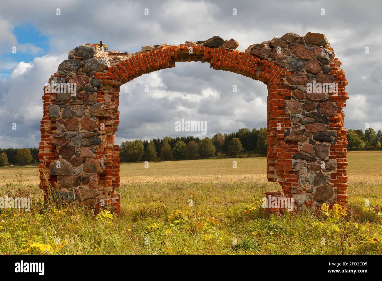 ruins of an old barn made of boulders and red bricks in the middle of a ...