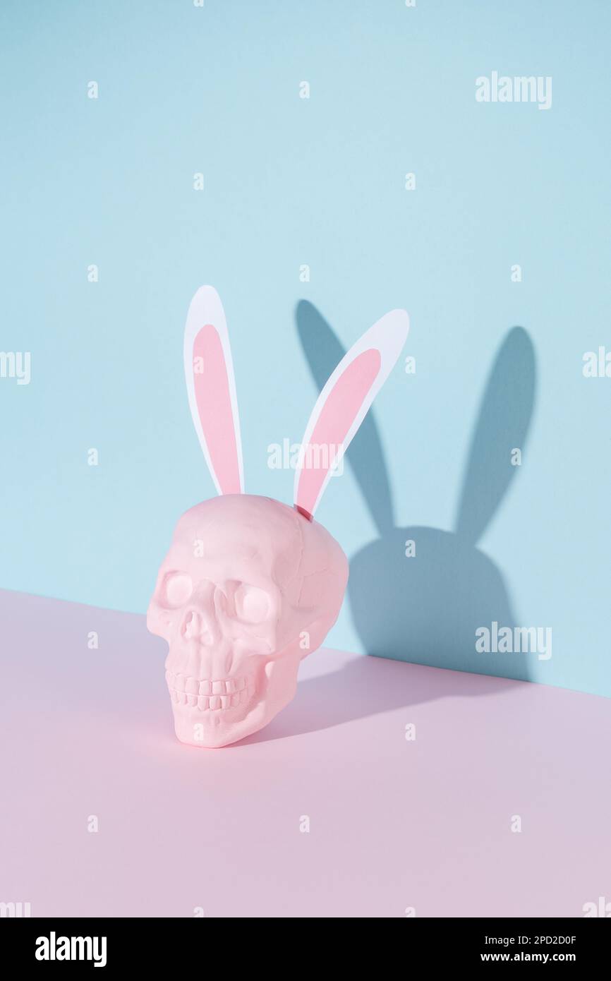 Pink skull with rabbit or bunny ears with sharp shadows on bright ...