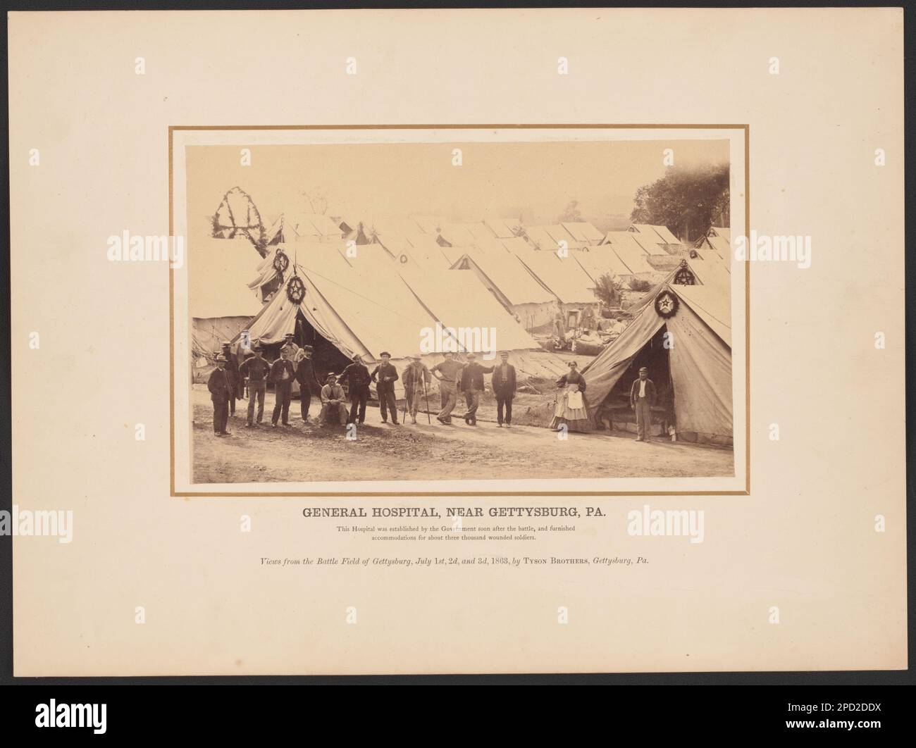 Group of wounded soldiers with two female nurses in front of tents at ...