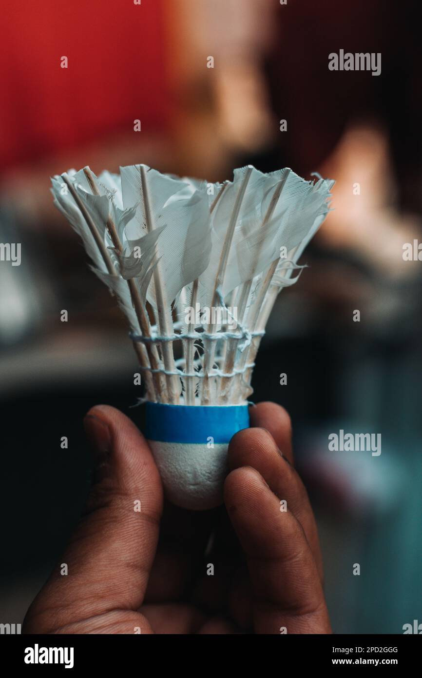A hand holding a used badminton shuttlecock Stock Photo - Alamy