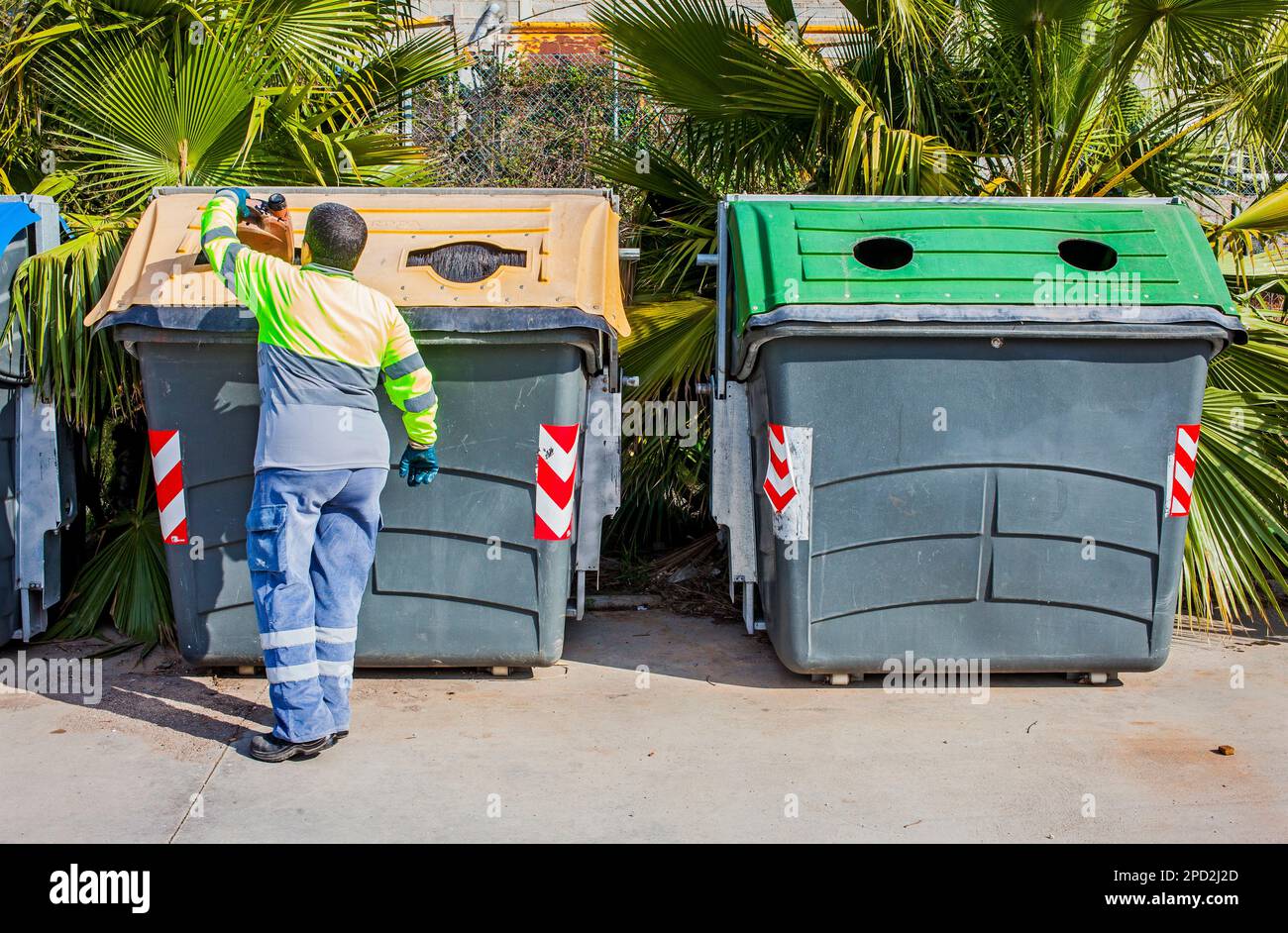 Containers of plastic and glass for waste separation. Man places ...
