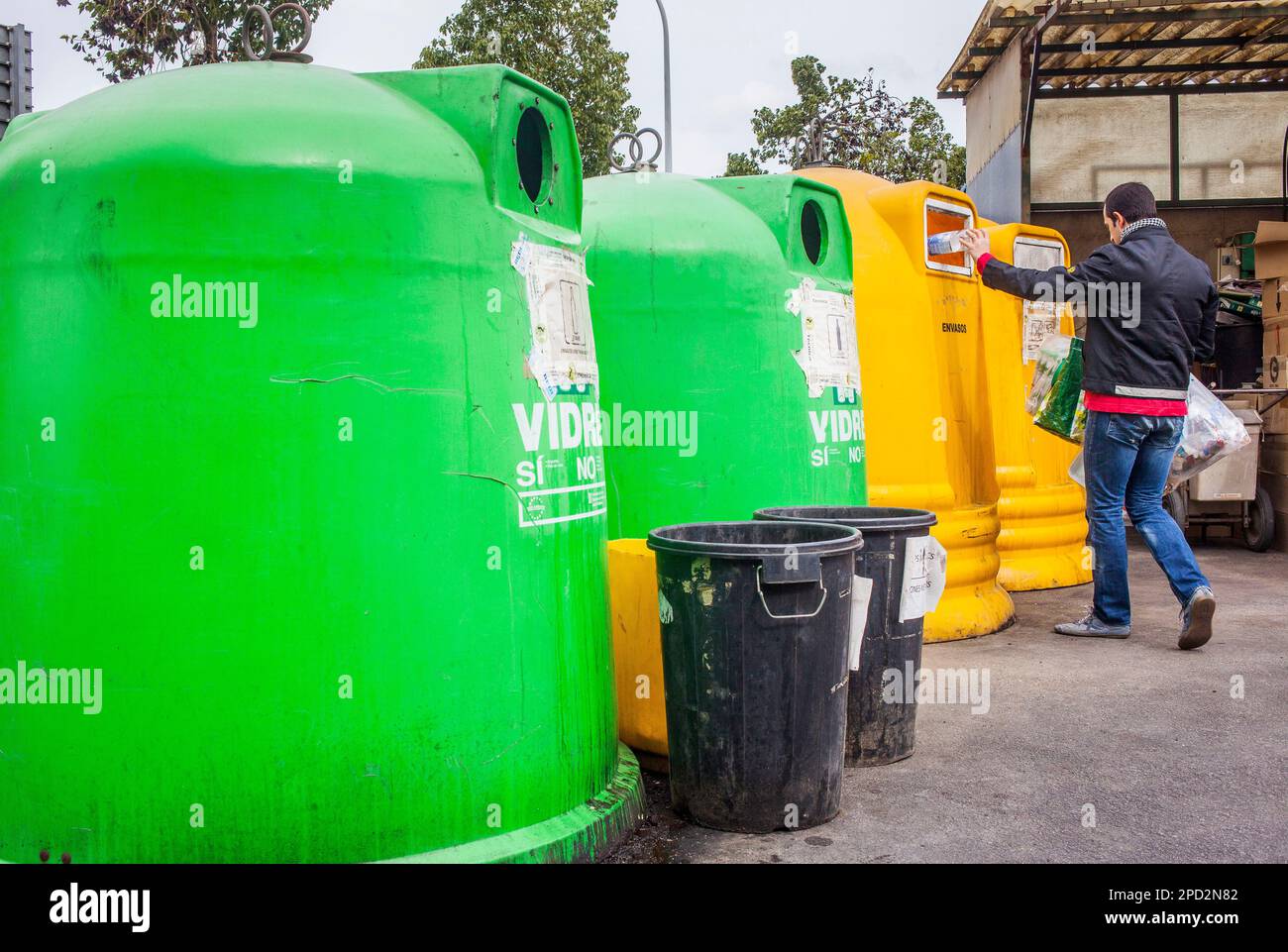 Containers of plastic and glass for waste separation. Man places ...