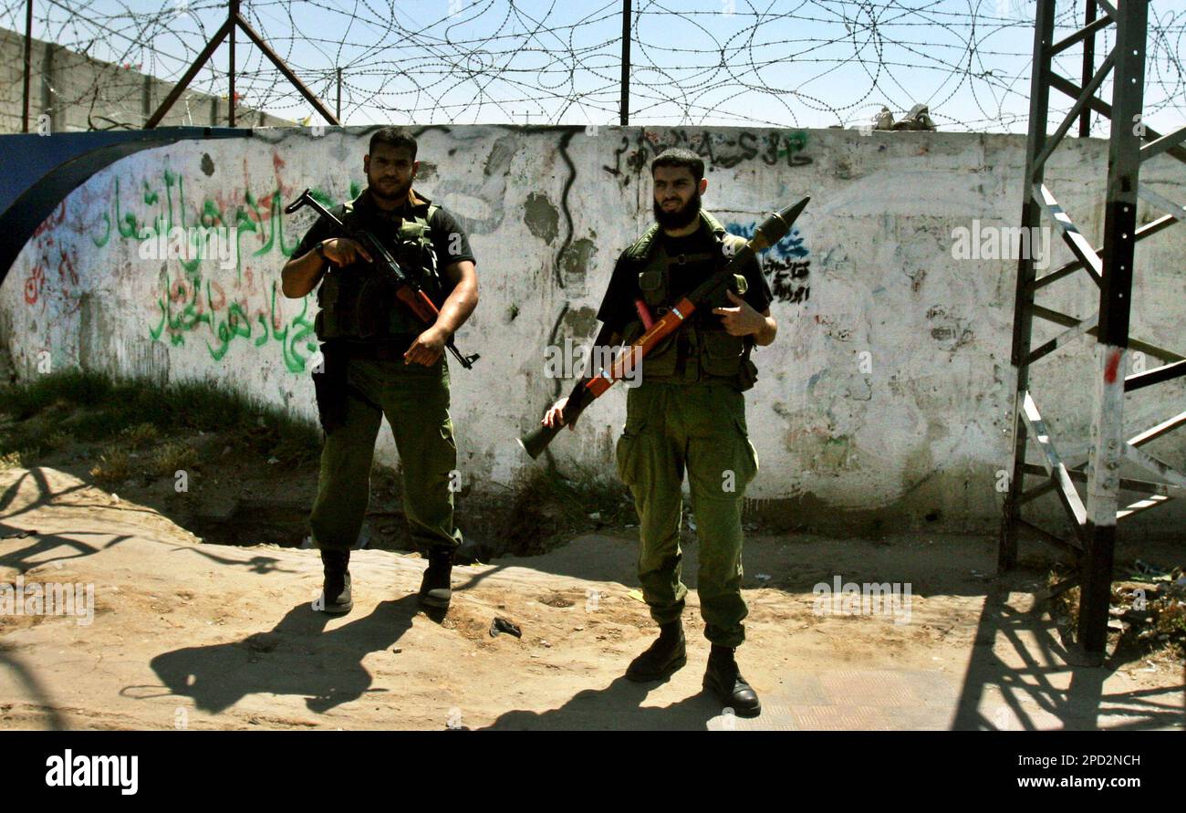 Palestinian militants of the Islamic group Hamas, one of them holding a ...