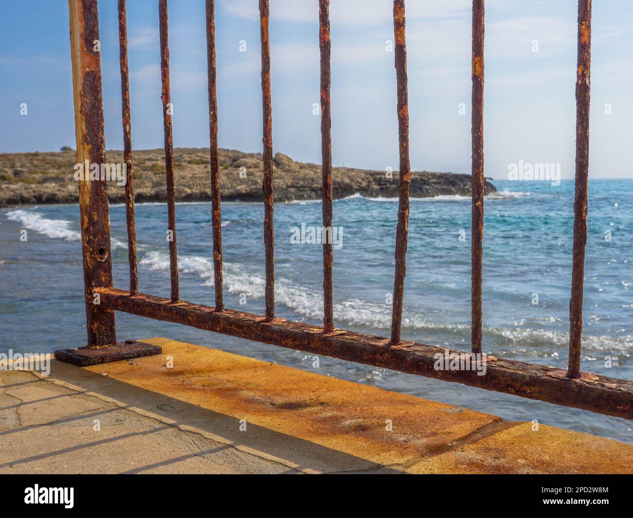 View from the pier through the rusty bridge fence over the ...