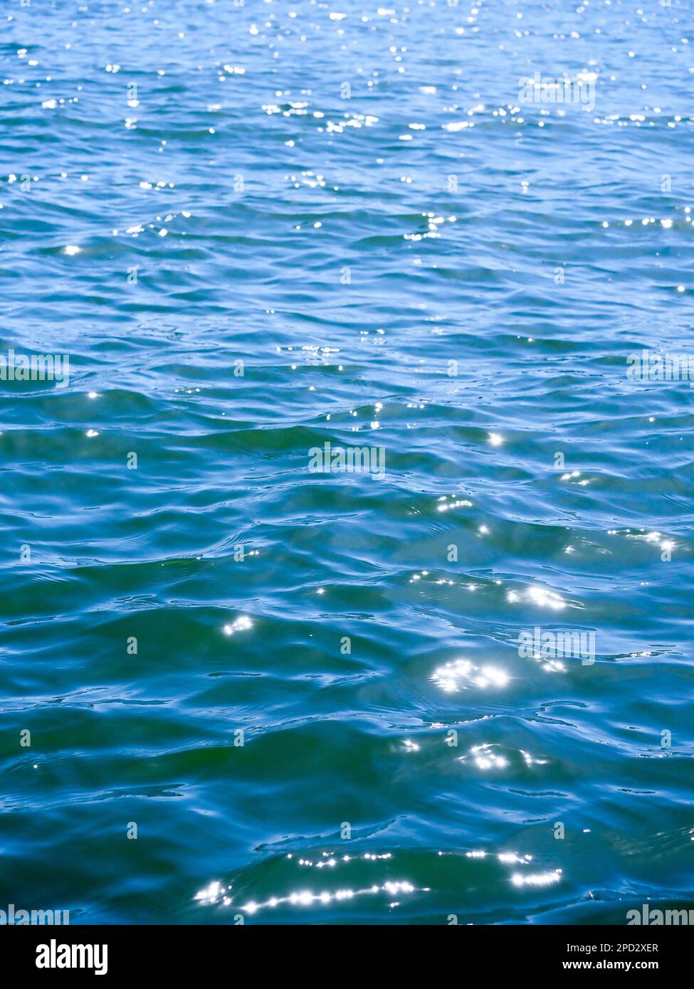 Vertical format picture of sunlight sparkling on blue water Stock Photo ...