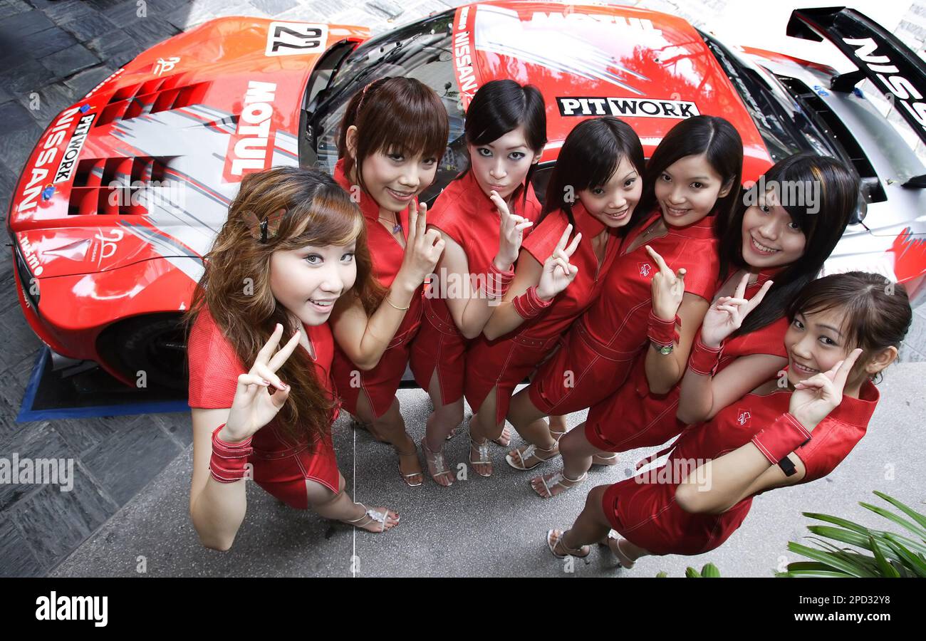 Malaysian GT girls pose next to the Nissan Skyline GT racing car after ...