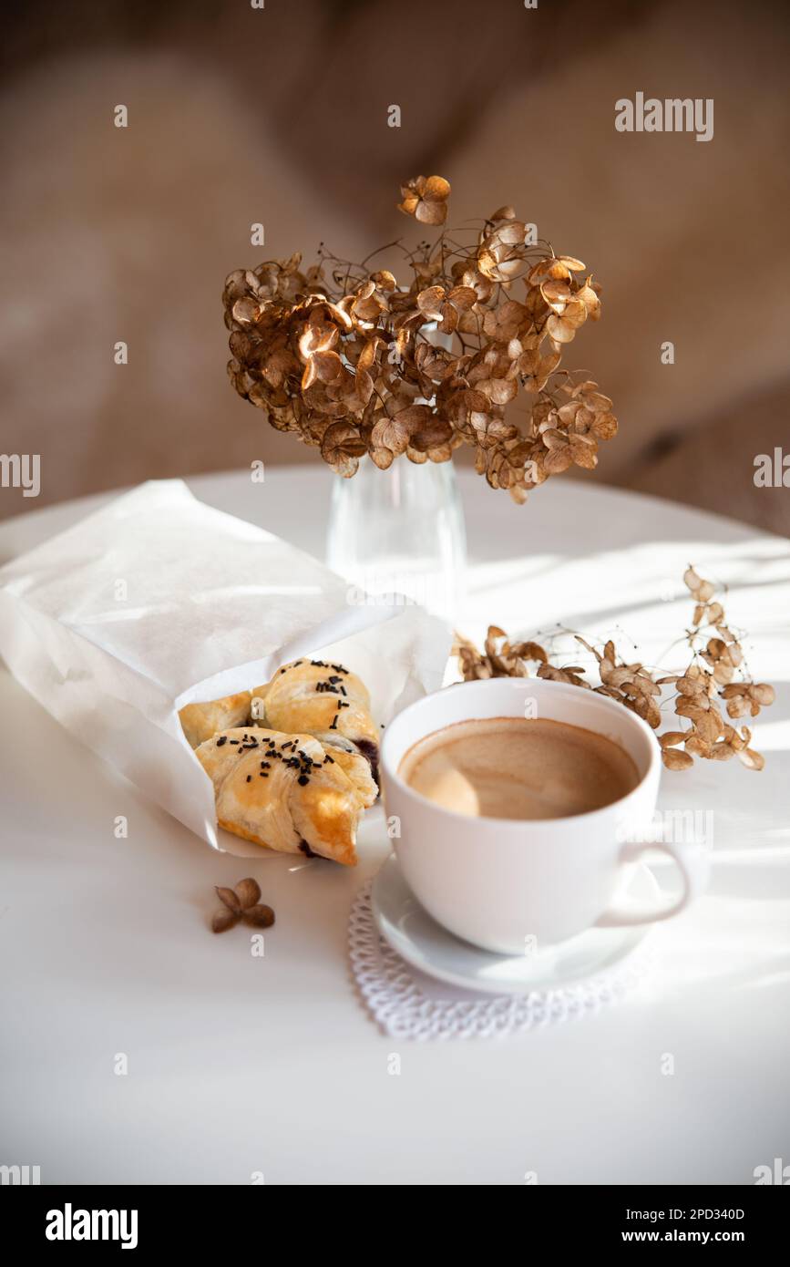 Breakfast in the sunny morning: coffee and croissants on white table in ...