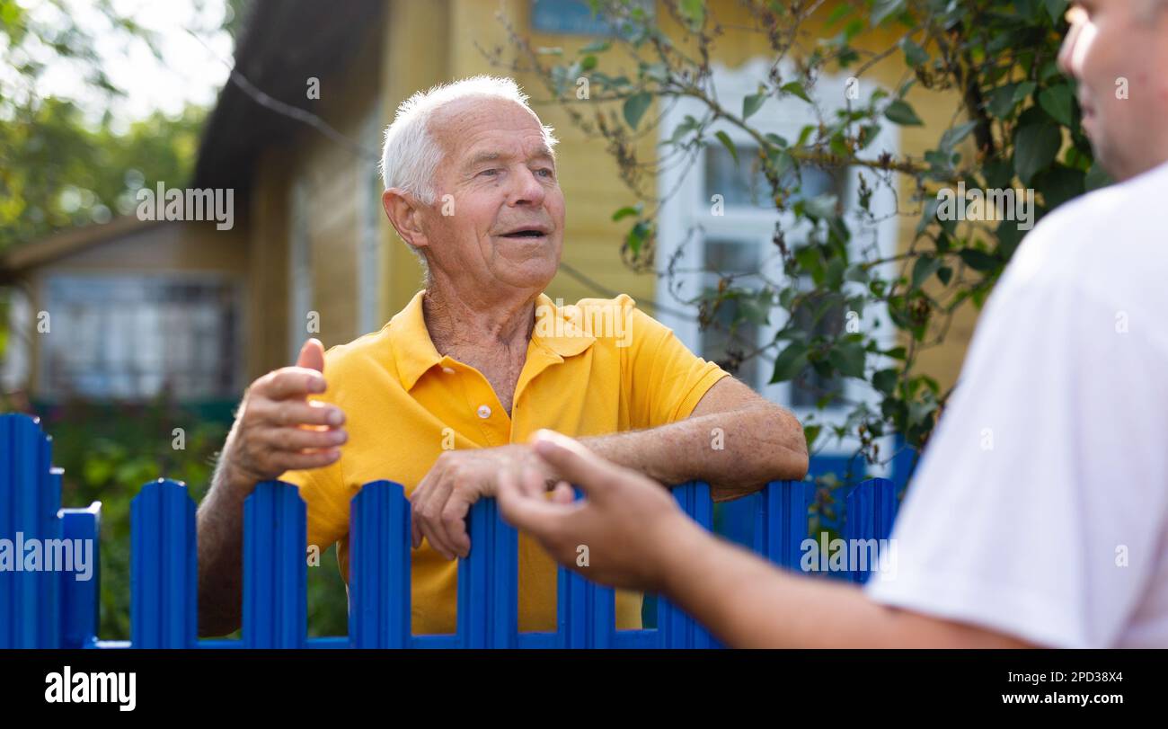 Old man talking with his neighbour Stock Photo - Alamy