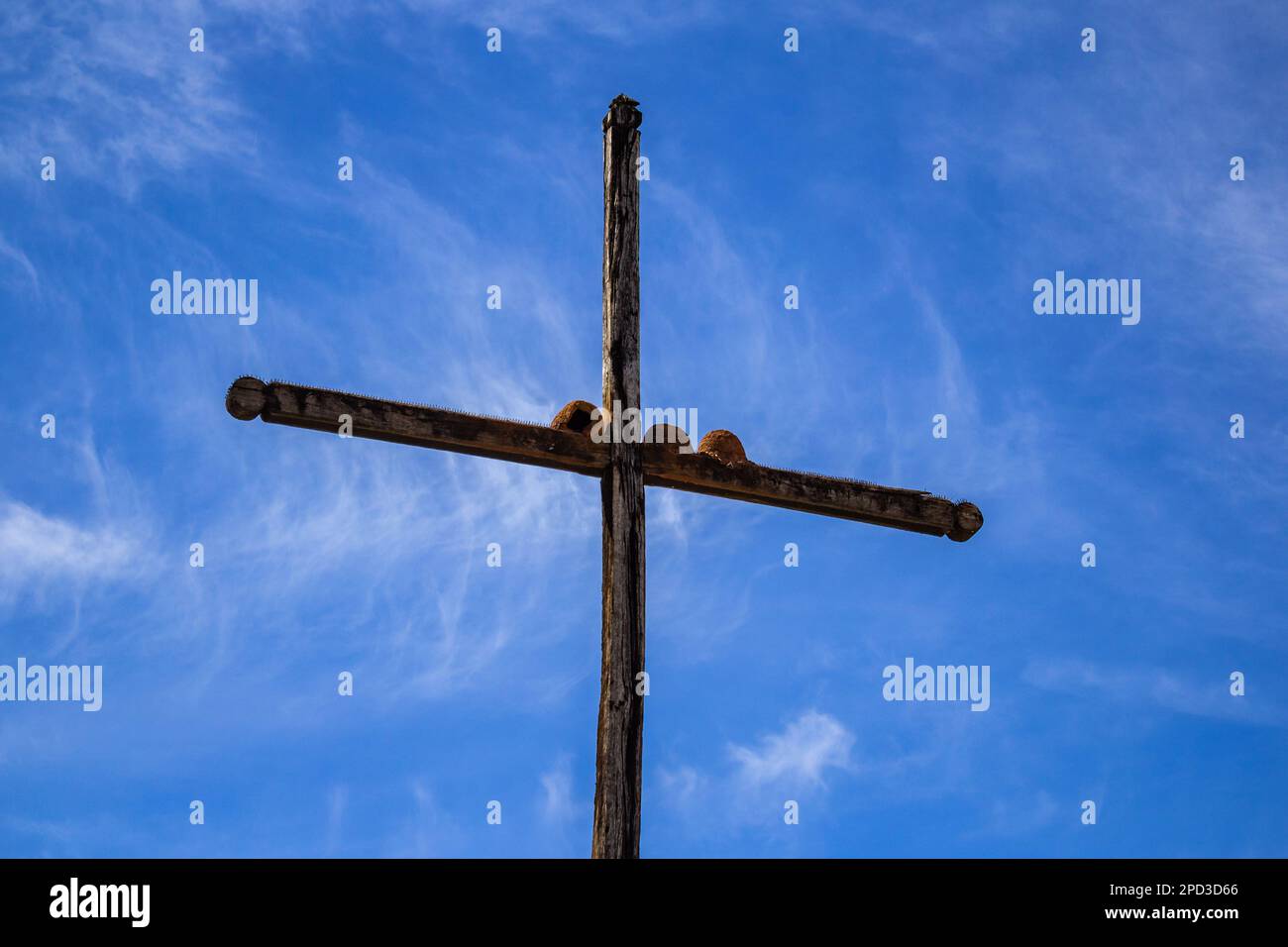 Three Rufous Hornero nests on a wooden cross with a blue sky in the ...